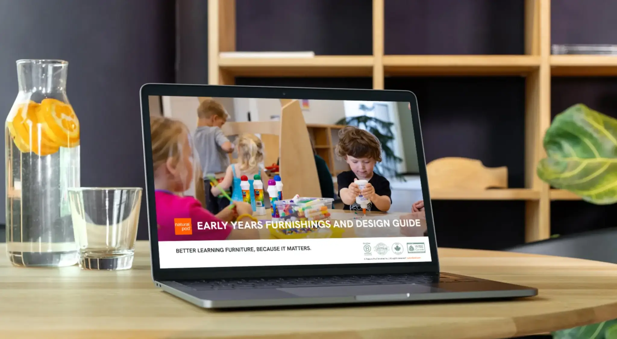 A laptop on a desk displaying the cover of the Natural Pod Early Years ...